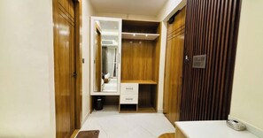 Um closet amplo com portas de madeira, um espelho e uma bancada branca.