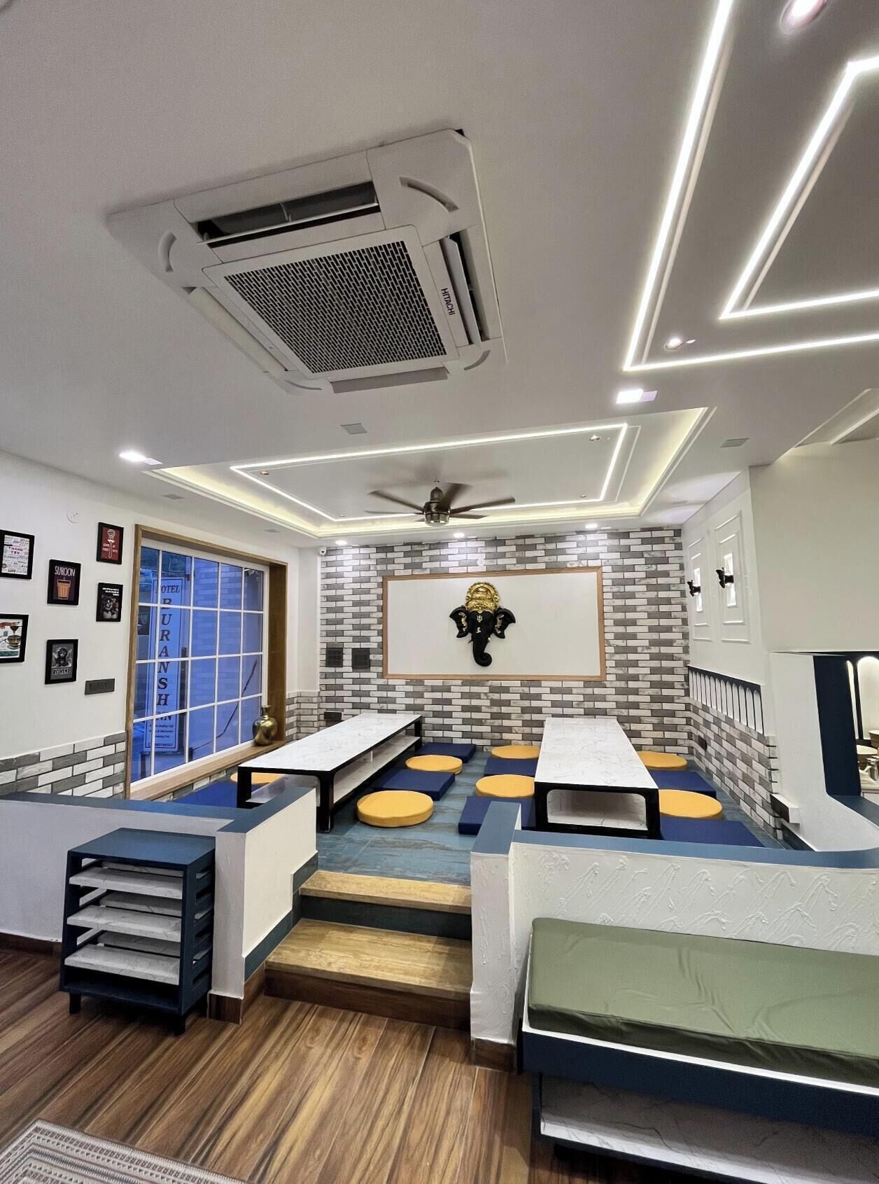 Um interior moderno com área de estar central, ventilador de teto e objeto decorativo fixado na parede.