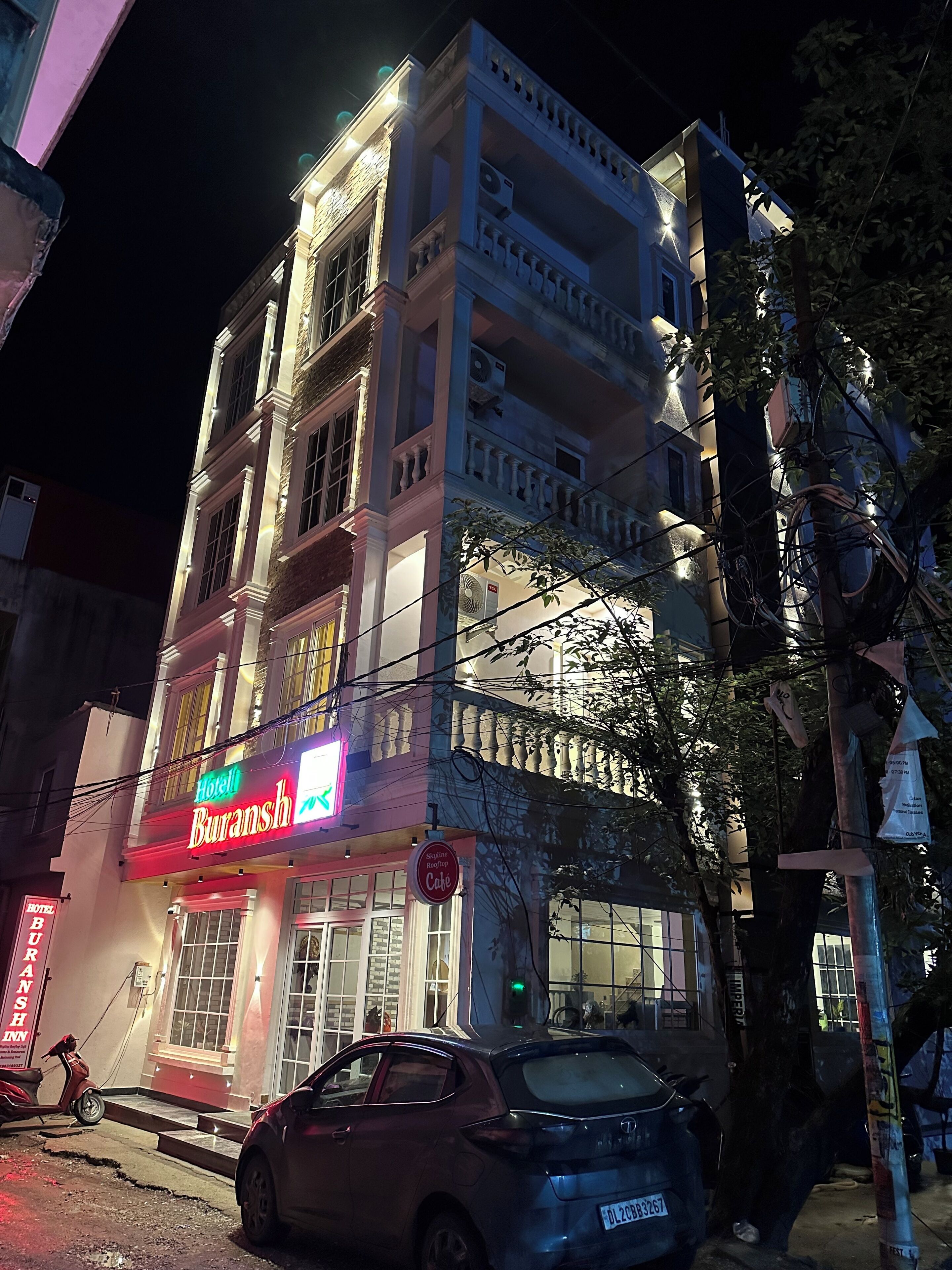Um hotel com vários andares e uma placa chamativa para 'Hotel Buranshi'.