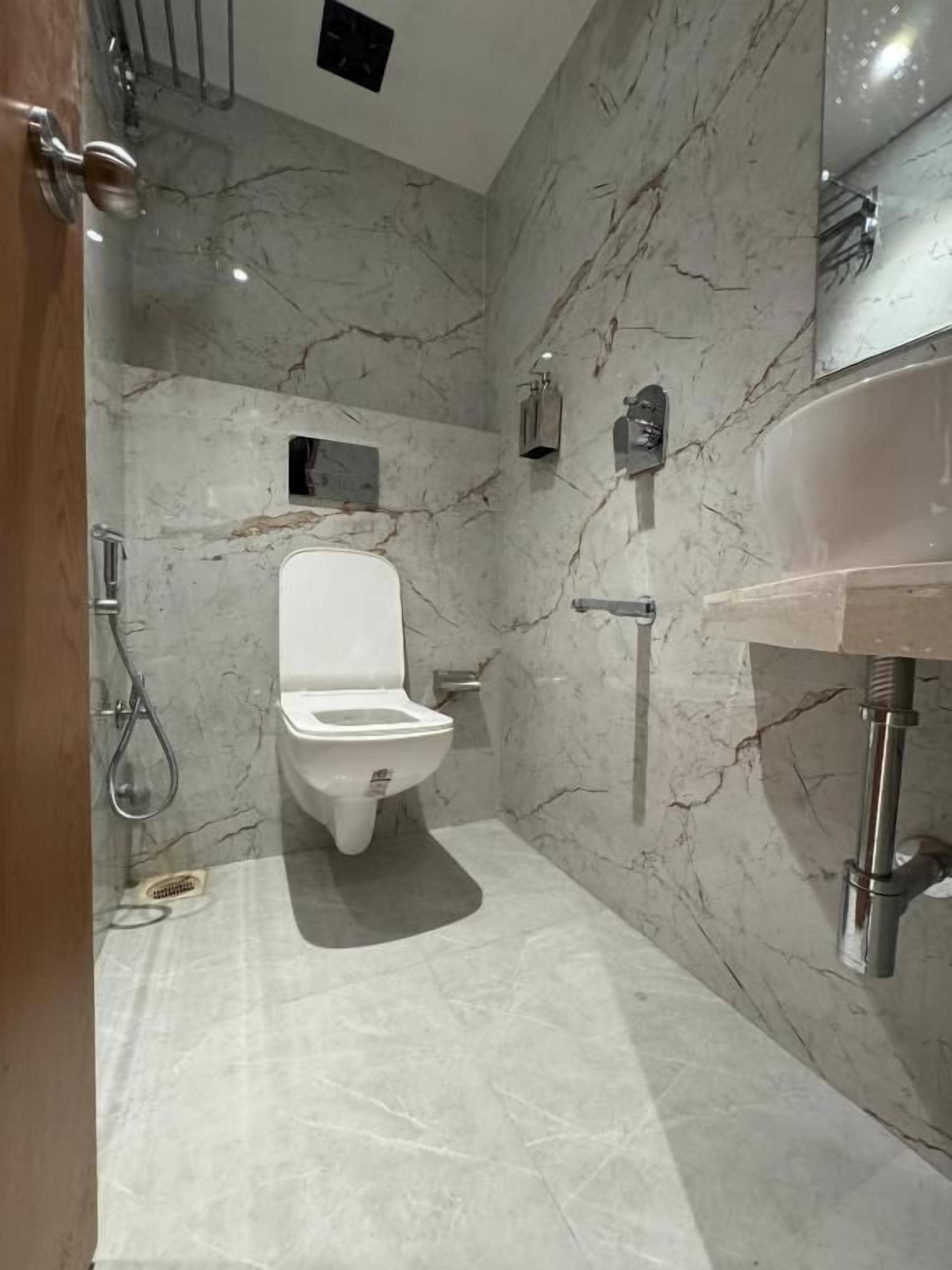 Uma casa de banho moderna com sanita, chuveiro e lavatório.