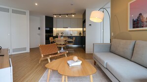 Uma sala de estar moderna com sofá, mesa de centro e área de jantar com cadeiras e mesa.