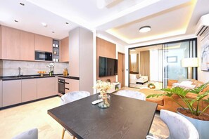 Quarto de hotel moderno com cozinha, sala de jantar e área de estar.