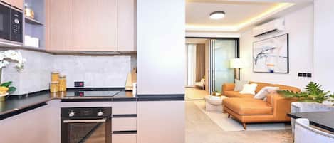 Cozinha moderna com forno Bosch, área de jantar com sofá e mesa de centro, e sala de estar com sofá e pintura na parede.
