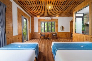 Quarto com duas camas, teto de madeira, mesa de jantar com cadeiras e uma janela grande.