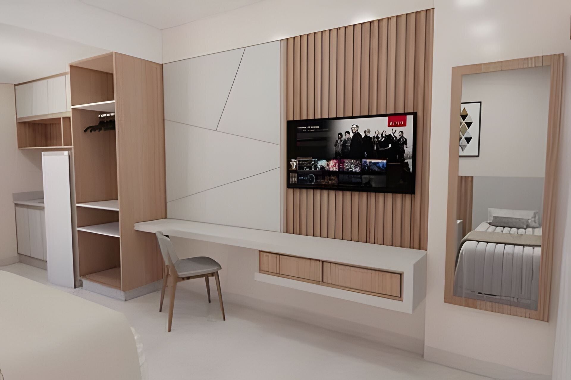 Quarto moderno com estantes embutidas, televisão de tela plana na parede, escrivaninha e radiador.
