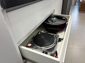 Uma gaveta de cozinha com churrasqueira embutida e fogão.