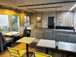 Interior moderno de café com disposição de assentos, balcão e obras de arte nas paredes.