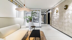 Um interior moderno com sofá, mesa, planta em vaso e parede com padrão.