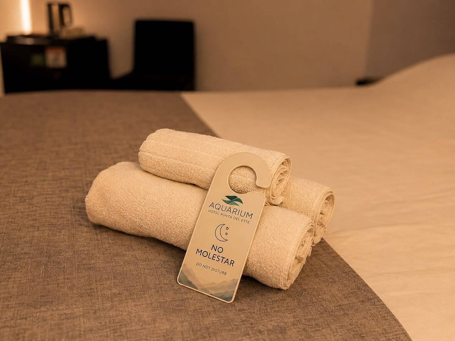 Toalha dobrada com etiqueta sobre a cama.