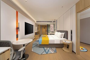 Quarto de hotel moderno com cama, mesa de cabeceira, escrivaninha, cadeira e TV de tela plana.