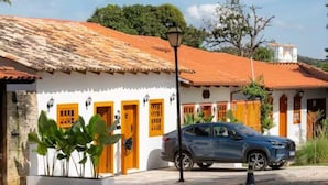 Um edifício branco com portas laranja e telhado de telhas vermelhas.
