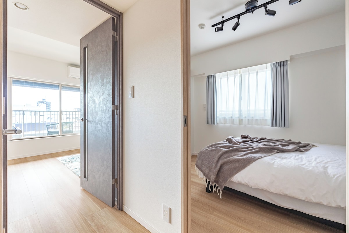 Quarto com cama, janela com cortinas e vista para o exterior.