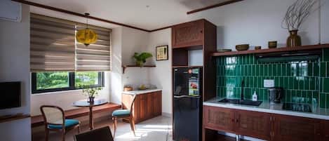 Cozinha moderna com geladeira embutida, armários de madeira e painel de azulejos verdes.