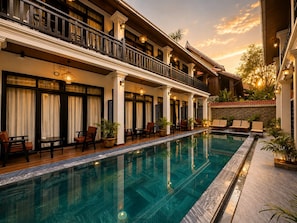 Hotel com piscina, área de estar externa e varanda.