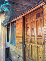 Uma porta de madeira com puxador de metal e janela com tela metálica.