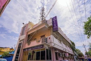 Um edifício de vários andares com uma placa chamativa para 'Home Vel-Ohm Stay'.