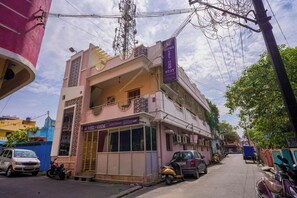 Um edifício de dois andares com uma placa indicando 'Vel-Ohm Stay', sinalizando um hotel ou pousada.