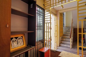Uma escada com corrimão amarelo, moldura de porta de madeira e portão de metal.