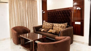 Uma sala de estar moderna com um sofá, duas poltronas e uma mesa de centro.