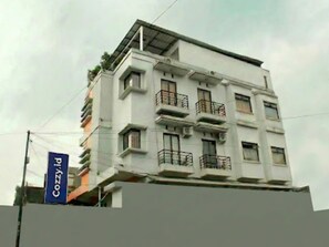 Um edifício com várias andares, varandas e janelas.