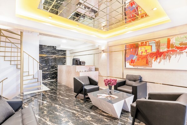 Um lobby moderno com piso de mármore, escada e máquina de café.