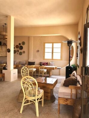 Uma sala de estar aconchegante com mesa de madeira, cadeiras e sofá.
