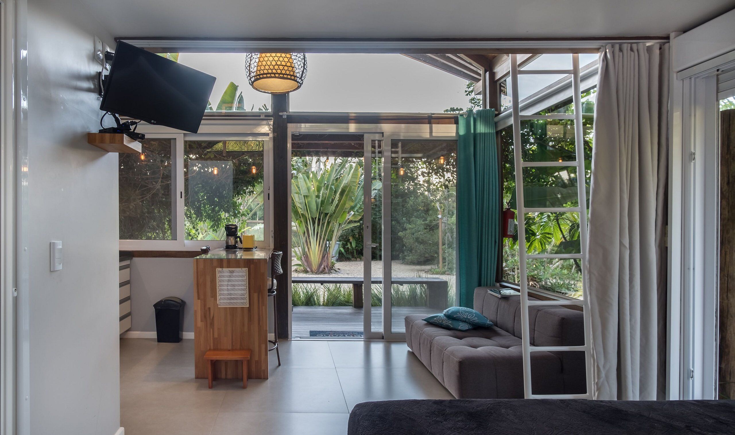 Uma sala de estar moderna com um sofá, uma mesa de centro e uma televisão fixada na parede.