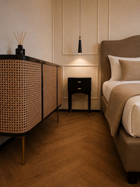 Quarto com cama, mesa de cabeceira, luminária e aparador de fibra.