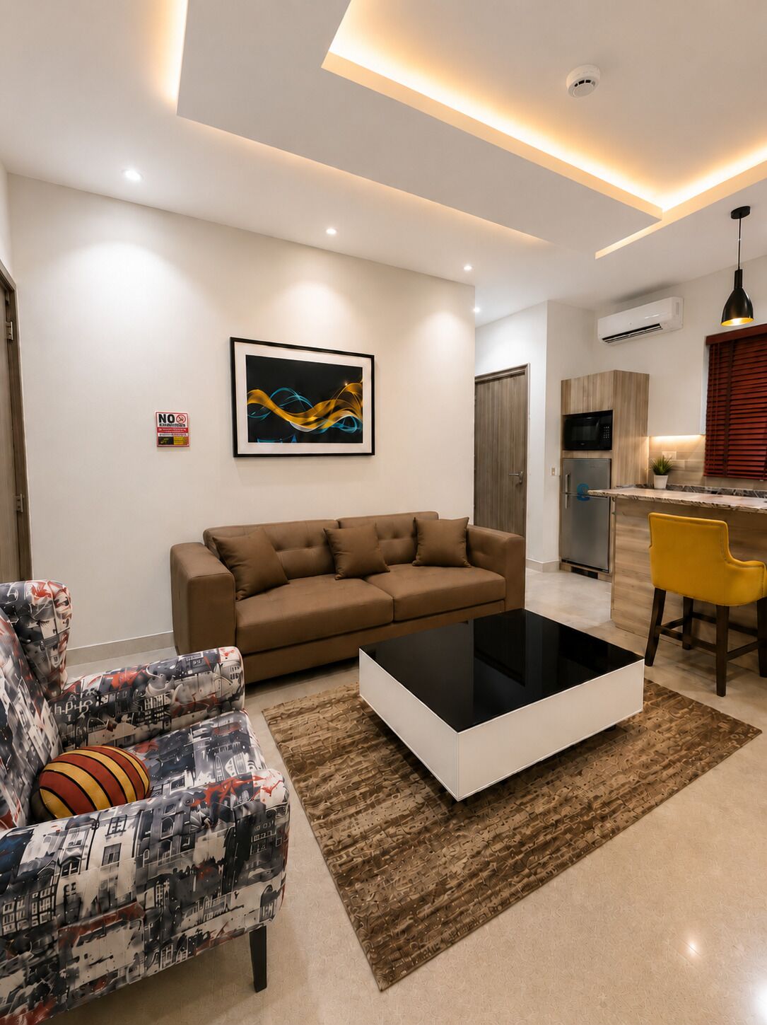 Uma sala de estar moderna com um sofá, uma mesa de centro e uma poltrona estampada.