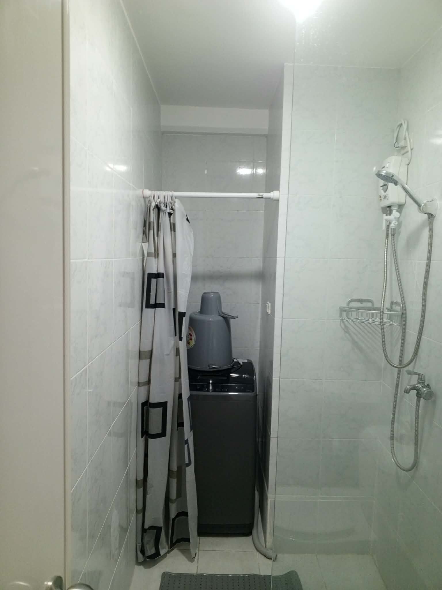 Pequeno espaço de chuveiro fechado, com chuveiro, porta-toalhas e aquecedor.