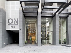 Entrada de um edifício moderno com uma placa grande indicando 'ON VILA MADALENA 2415'.