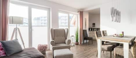 Uma sala de estar moderna com sofá, pufê e mesa de jantar.