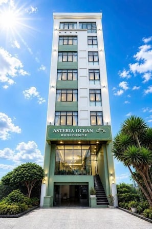 Um edifício alto com uma placa que diz 'Asteria Ocean Residence'.