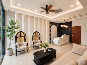 Uma sala de estar moderna com ventilador de teto, sofá, mesa de centro e planta decorativa.