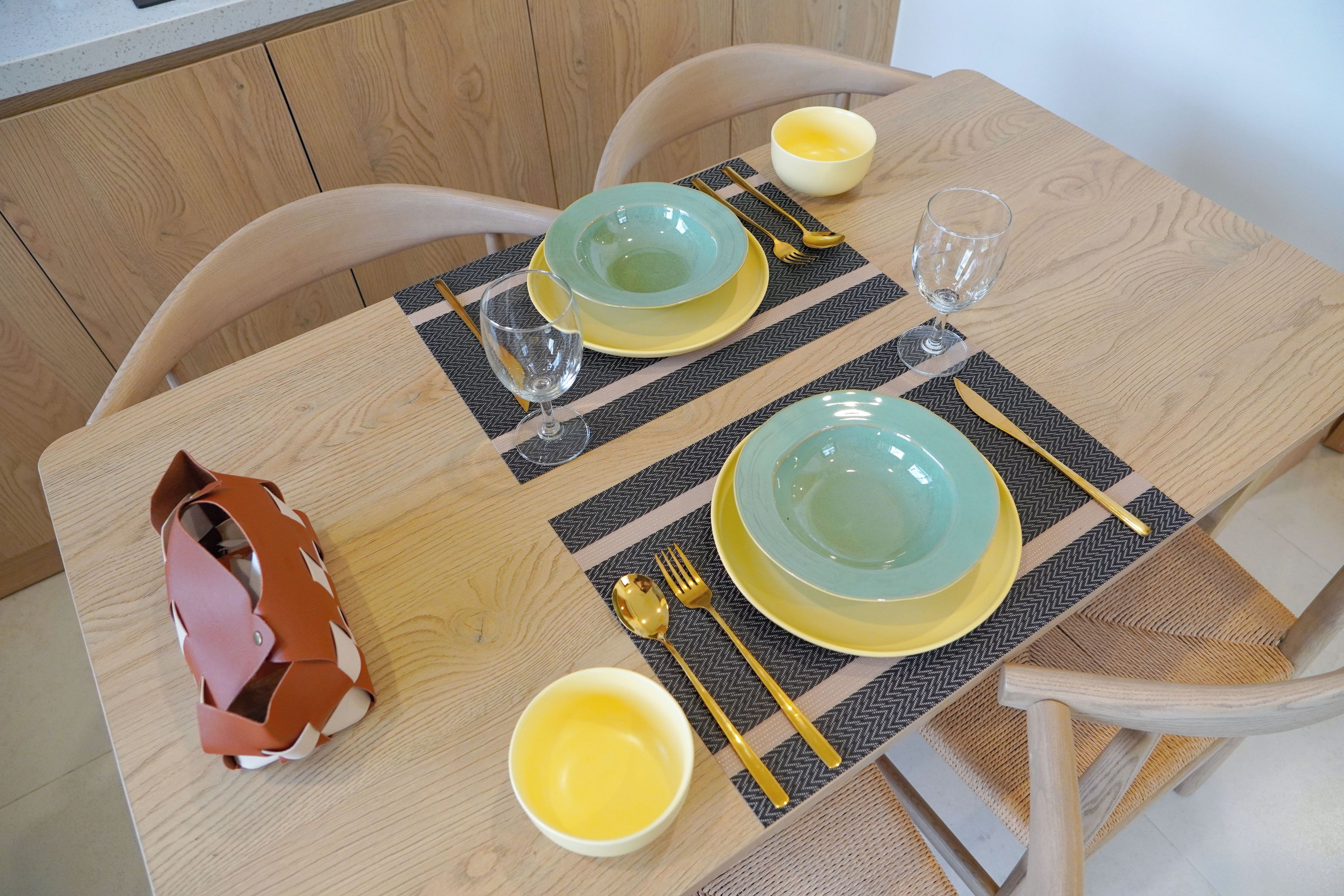 Uma mesa de jantar posta com pratos, talheres e copos.