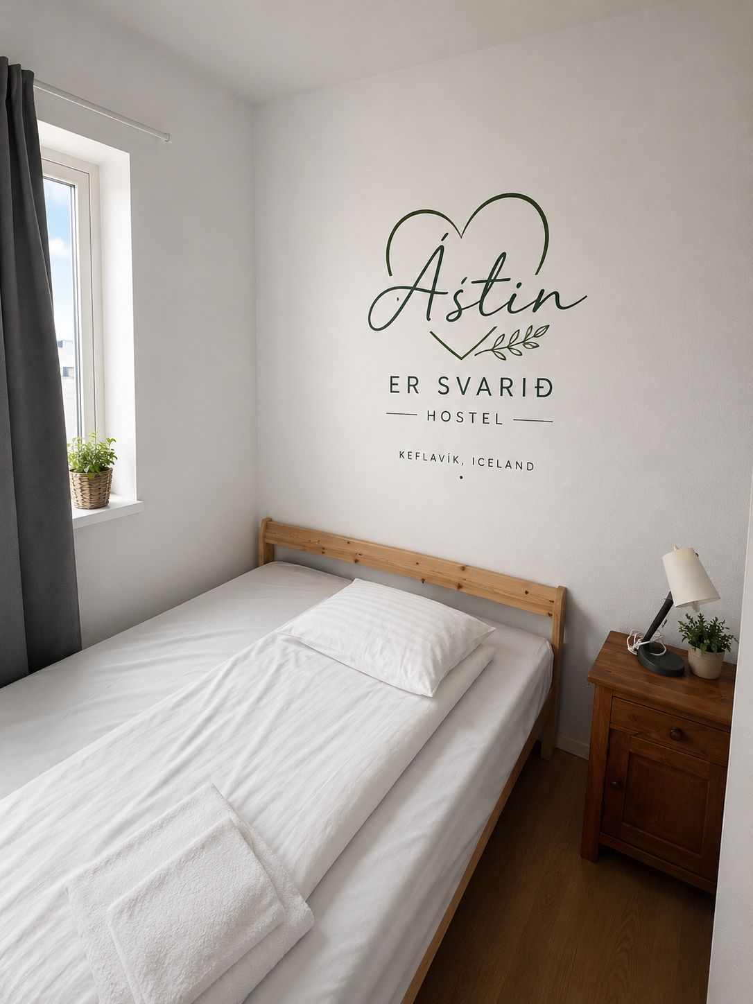Quarto minimalista com uma cama, mesa de cabeceira com abajur e uma decoração na parede.
