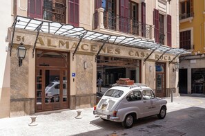 Carro antigo estacionado em frente a um prédio com uma placa indicando 'CASA ROCA'.