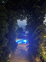 Uma trilha leva a uma piscina cercada por vegetação densa.