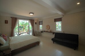 Quarto com cama, escrivaninha, cadeira, sofá e janela com cortinas.