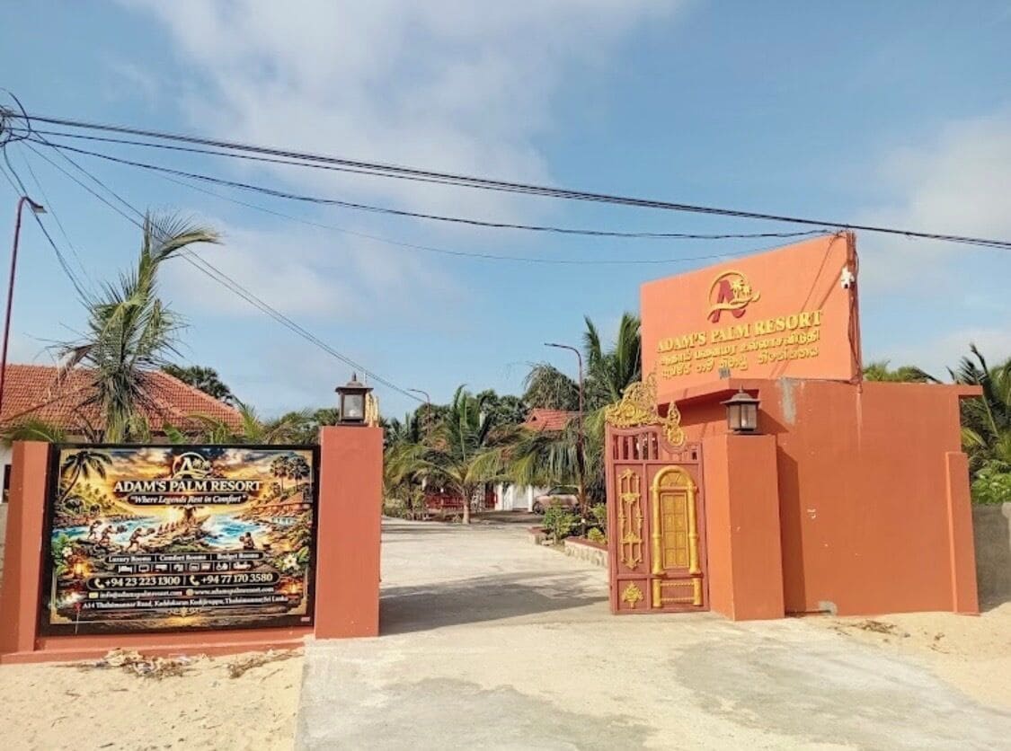 Entrada de um resort, com placa de identificação e portão.