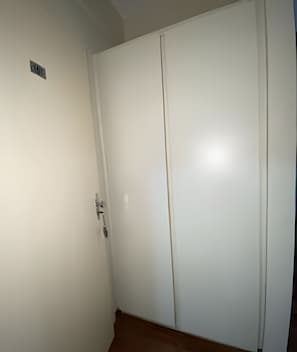 Uma porta branca fechada, com maçaneta e um pequeno respiradouro acima.