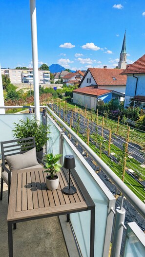 Uma varanda com mesa, cadeiras e um vaso de planta.