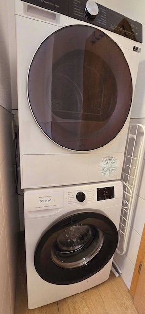 Máquina de lavar e secar empilhadas, com painel de controle e porta transparente.