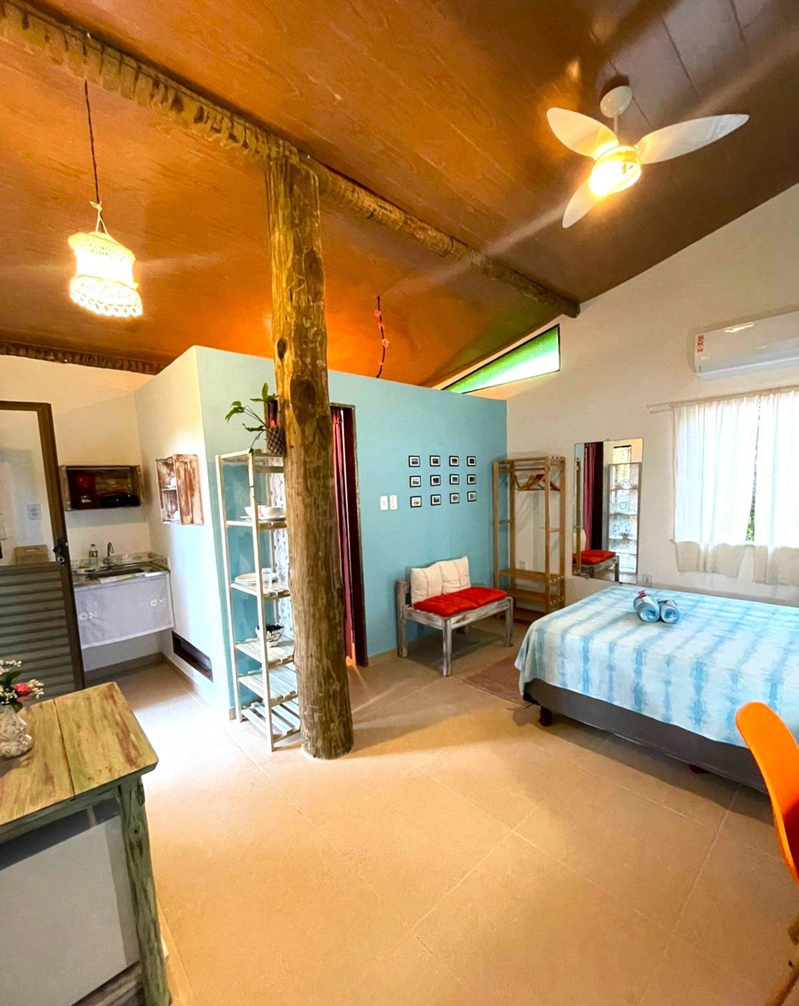 Quarto com cama, cadeira, estante e guarda-roupa.