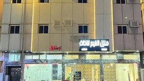 Um hotel com vários andares, letreiros iluminados e lojas na parte inferior.