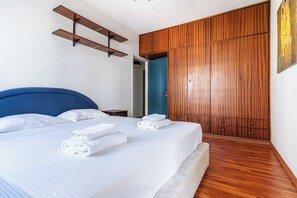 Quarto de hotel com cama, guarda-roupa e um quadro na parede.