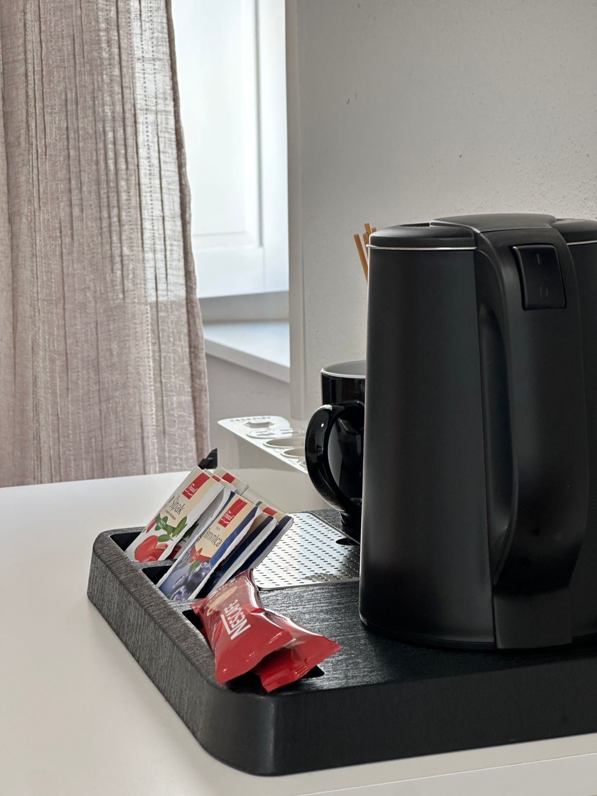 Máquina de café e bandeja com lanches em uma bancada.