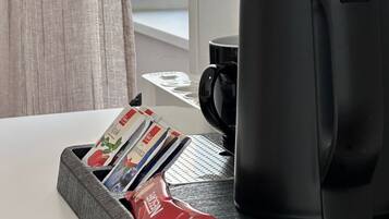 Máquina de café e bandeja com lanches em uma bancada.