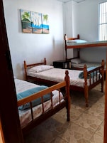 Um dormitório com beliches, um quadro na parede e uma janela.