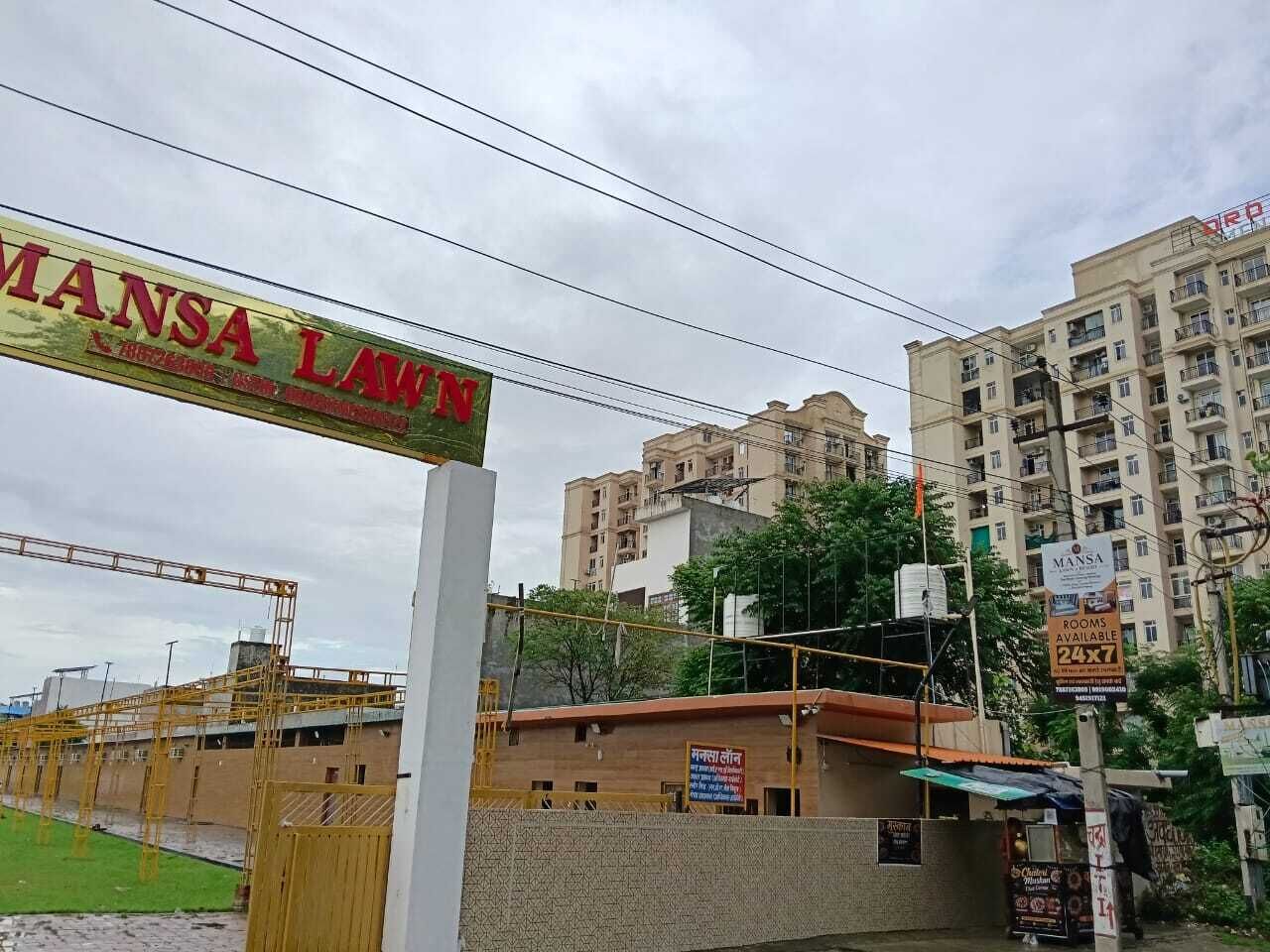 Placa de Mansa Lawns com um edifício alto ao fundo.